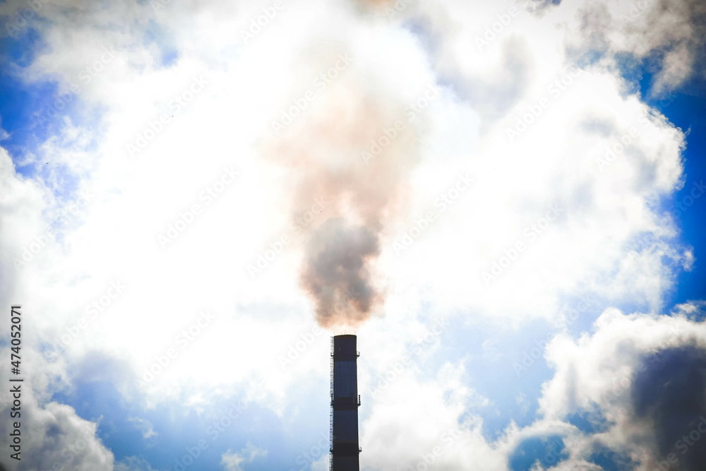 top tube factory with smoke from it against the sky with a bright ...