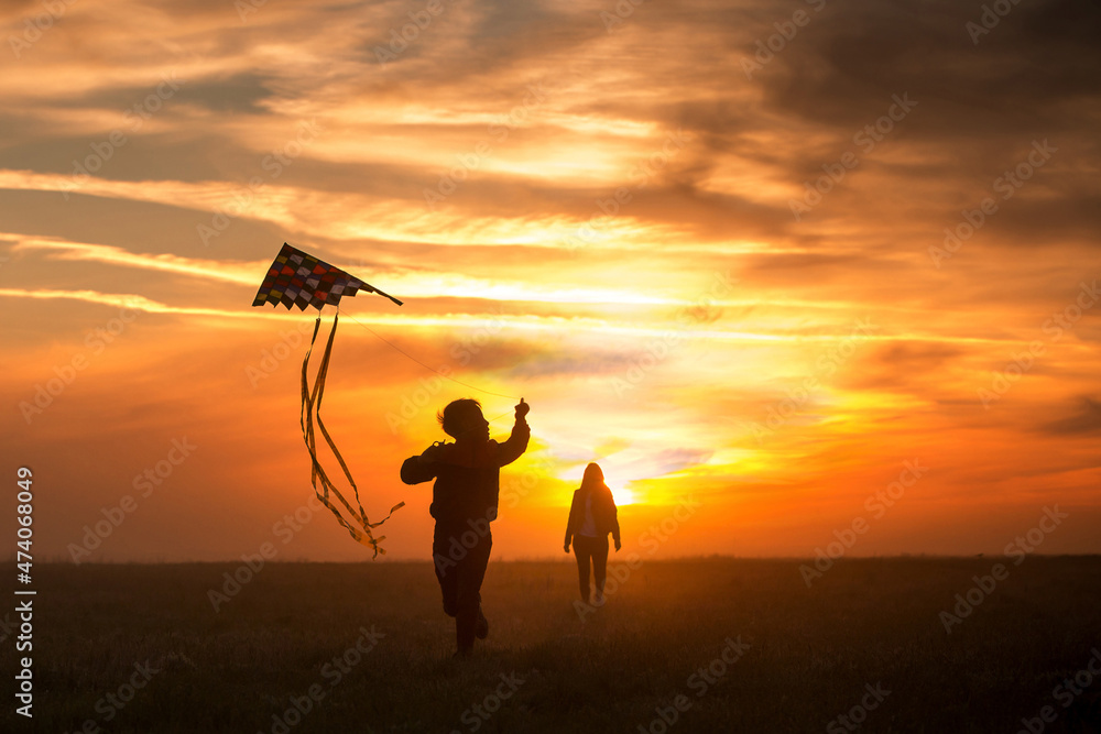 Flying a kite. Girl and boy fly a kite in the endless field. Bright ...