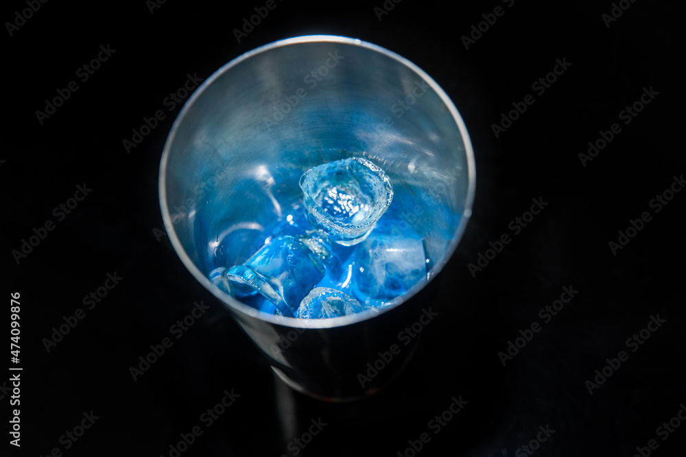 Blue cold syrup with ice in a tool for mixing and making alcoholic ...