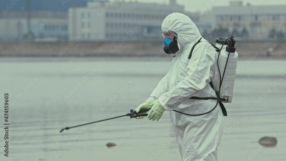 Medium slowmo portrait of male ecologist in chemical suit and ...