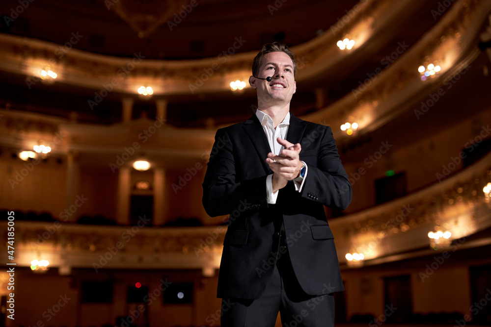 Talented business couch standing on stage clapping hands, keep hands ...