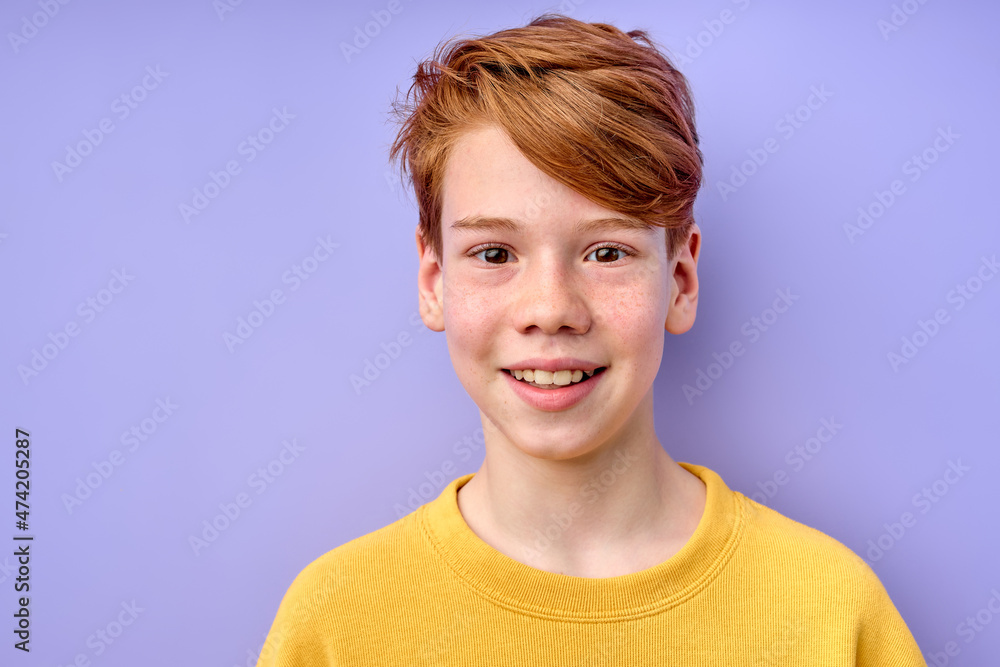 Young emotional handsome boy standing on purple studio background ...