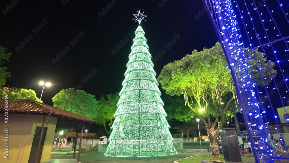 Arvore de Natal em praça de cidade, ao ar livre com luzes de natal ...