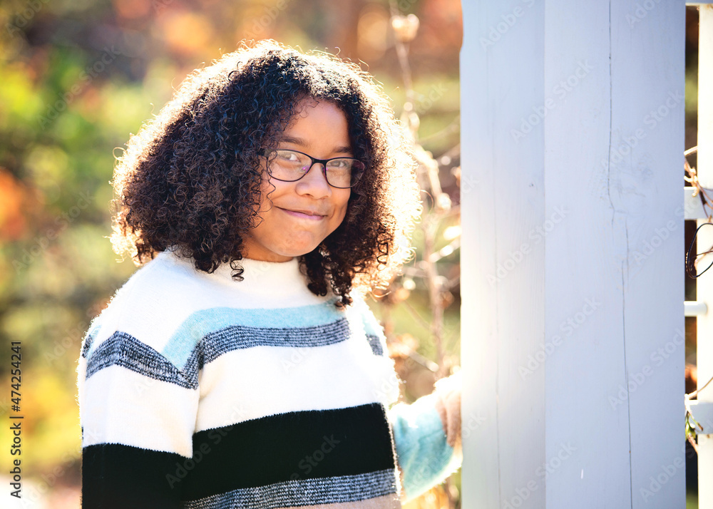 Smiling tween girl outdoors in fall colors. Stock Photo | Adobe Stock