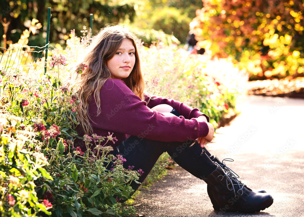 Beautiful tween girl sitting on path in fall colors. Stock-Foto | Adobe ...