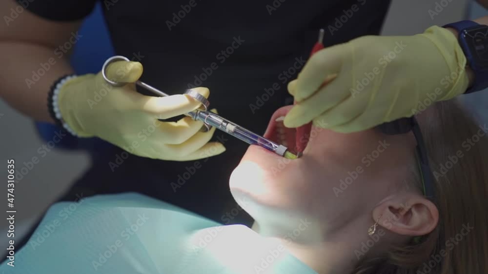 real. dentist injects an anesthetic into patient before tooth ...