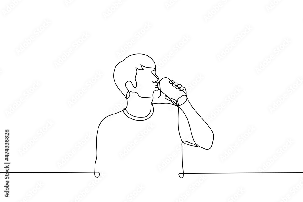 man stands and drinks beer, energy drink or soda from aluminum can ...