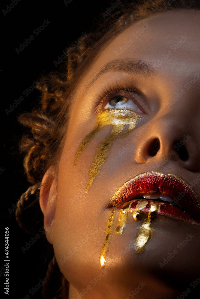 Gold on the skin, face art and creative makeup, gold as tears and blood ...