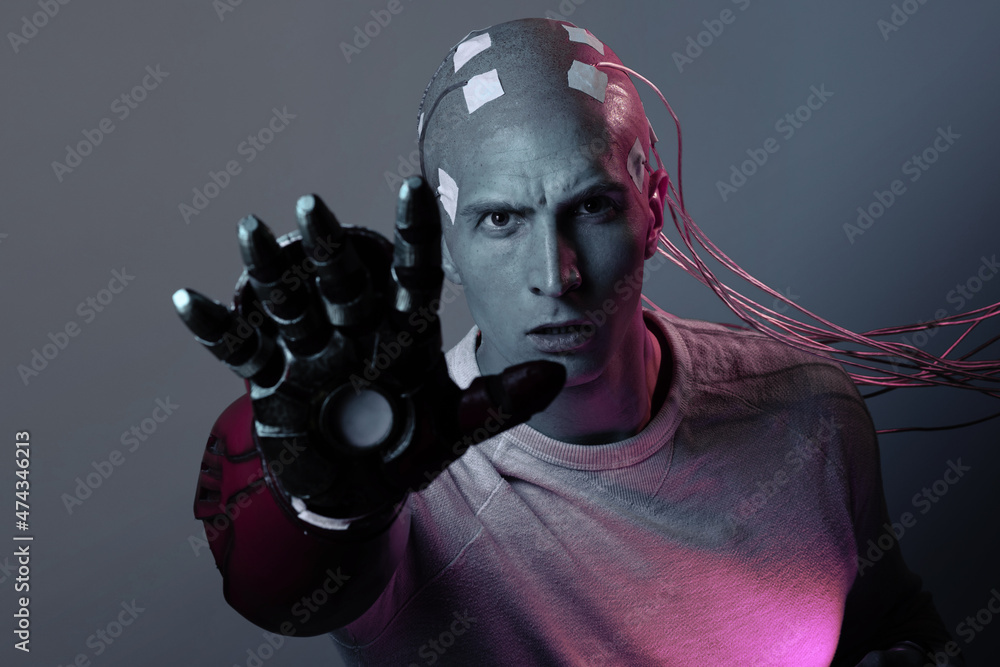 young man with a head entangled with wires and with a robotic arm ...