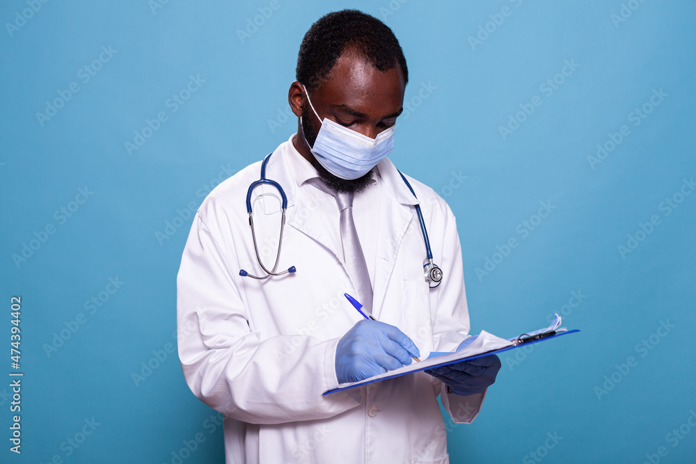 Doctor looking down at clipboard with patient charts wearing lab coat ...