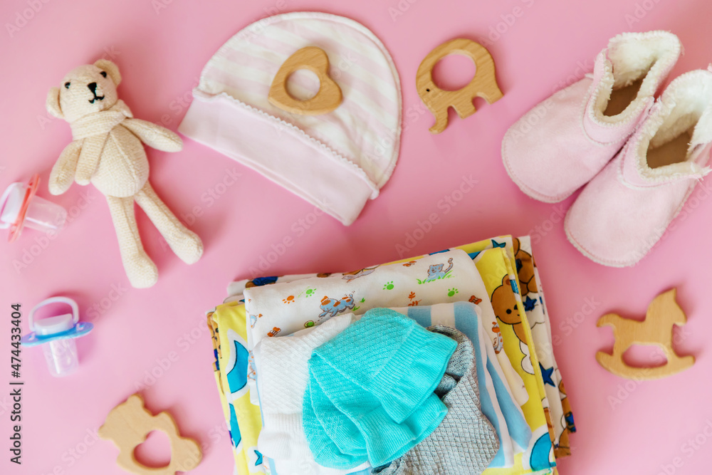 Baby clothes and accessories on the pink background. Selective focus ...
