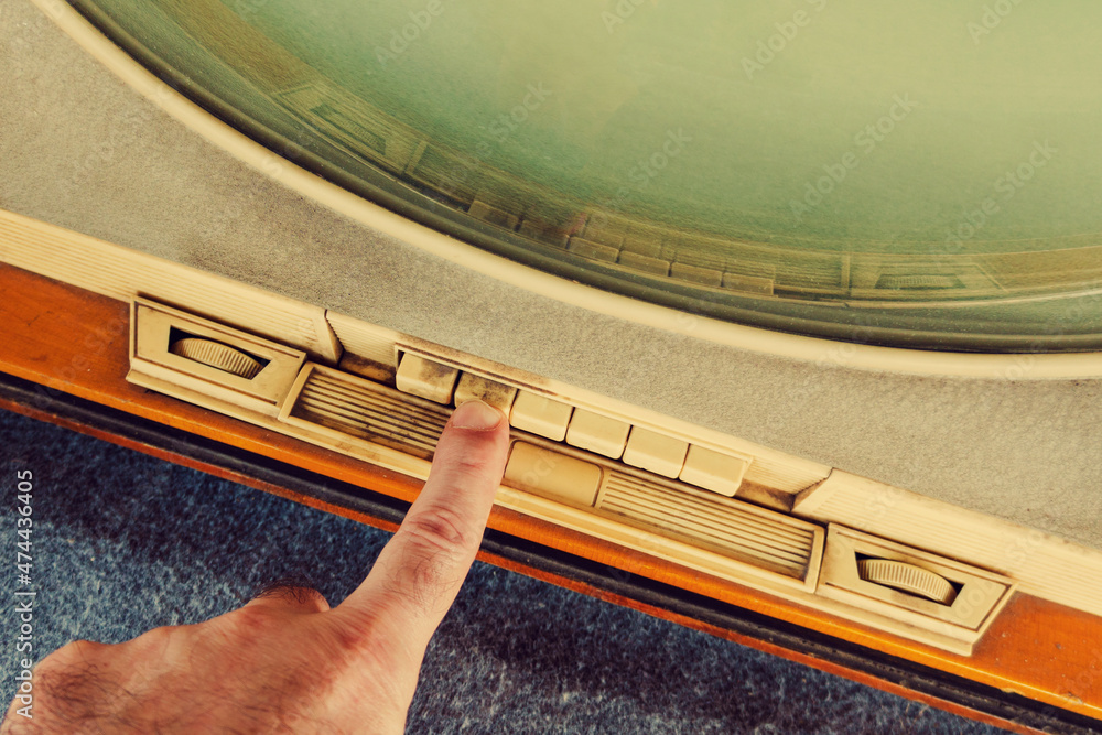 The hand changes channels on the retro old TV. Turning on of the ...