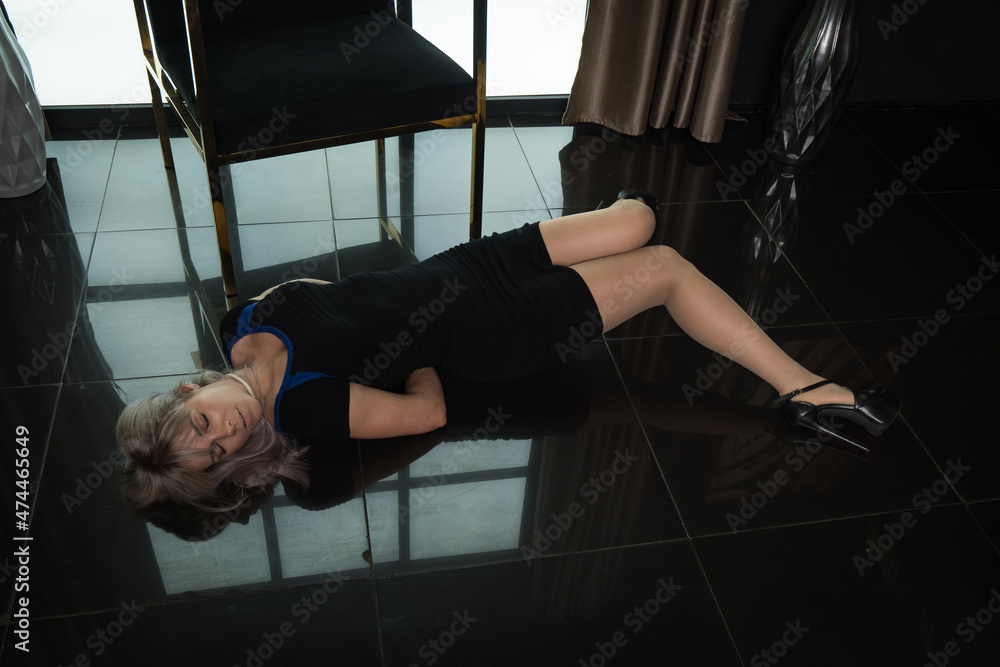 Crime scene simulation: dead girl with hands tied lying on the floor ...