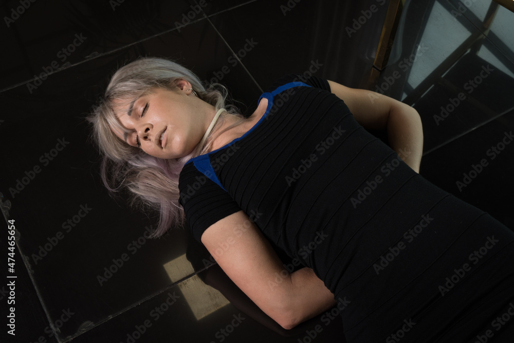 Crime scene simulation: dead girl with hands tied lying on the floor ...