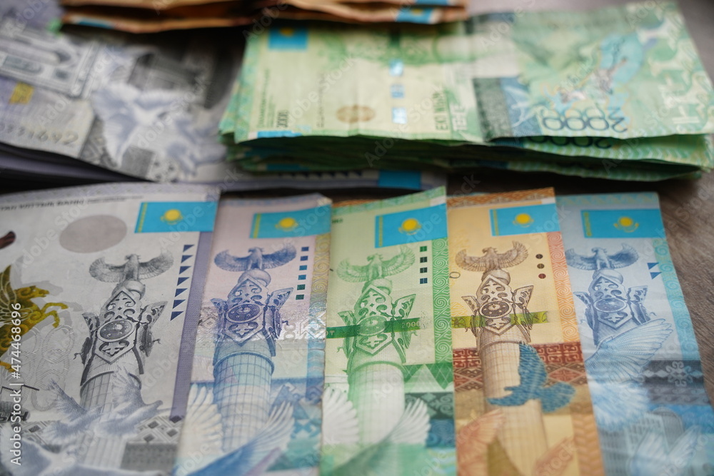 Banknotes of Kazakhstani tenge of different denominations lie on top of ...