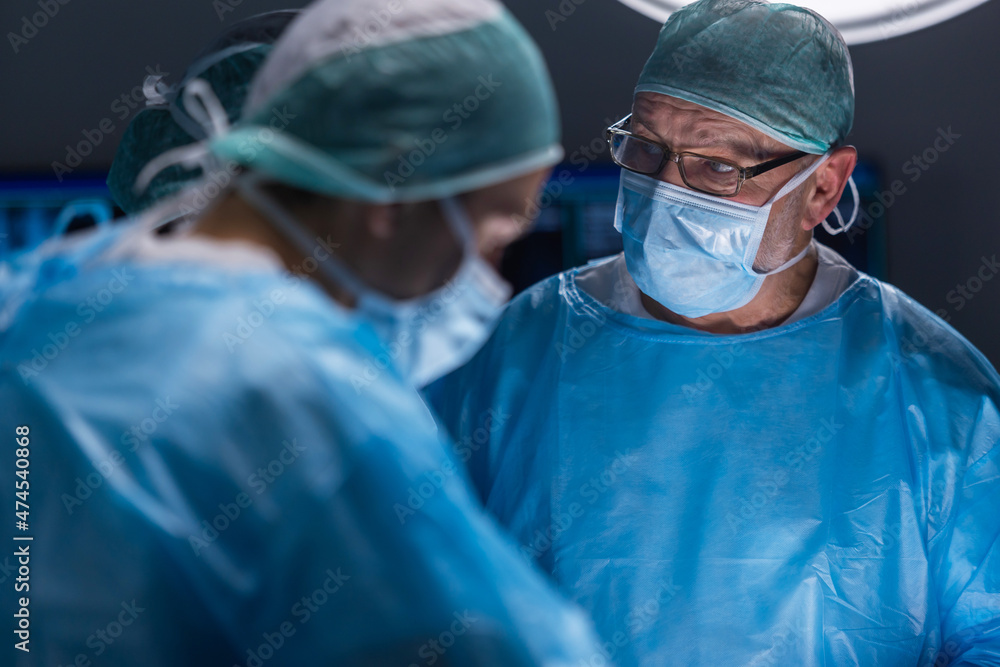 Multiracial team of professional medical surgeons performs the surgical ...