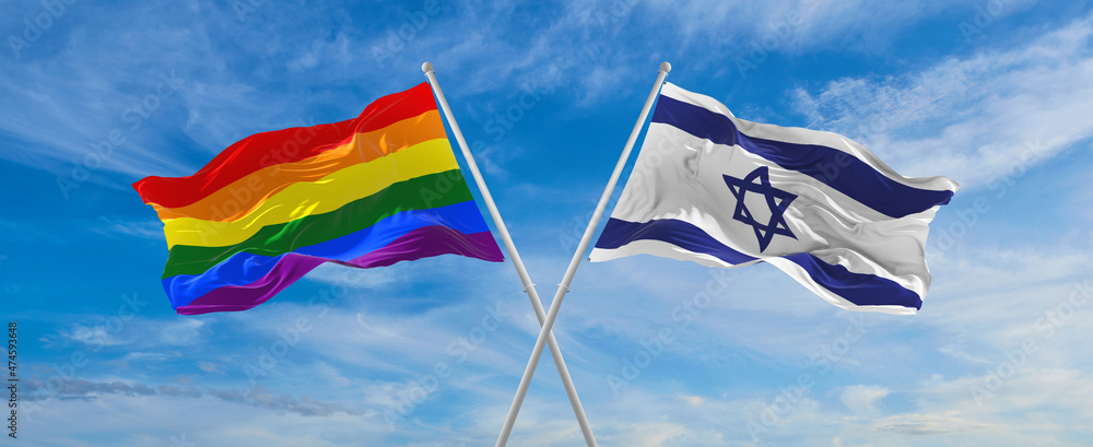 crossed flags of lgbt and Israel flag waving in the wind at cloudy sky ...