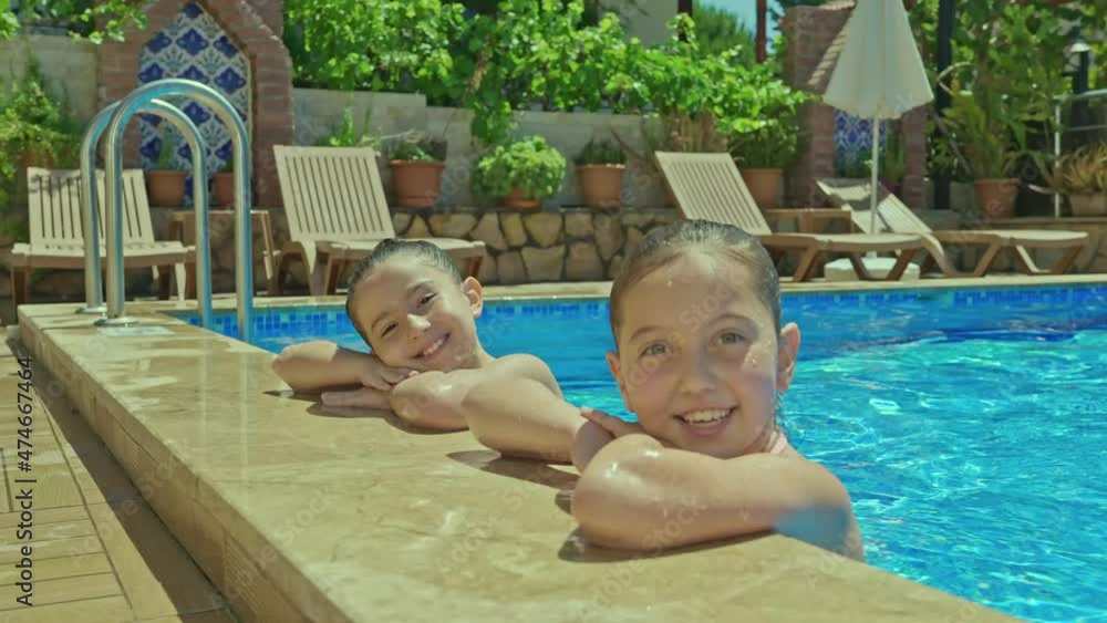 Little beautiful girls swimming in the pool, playing in the water.Happy ...