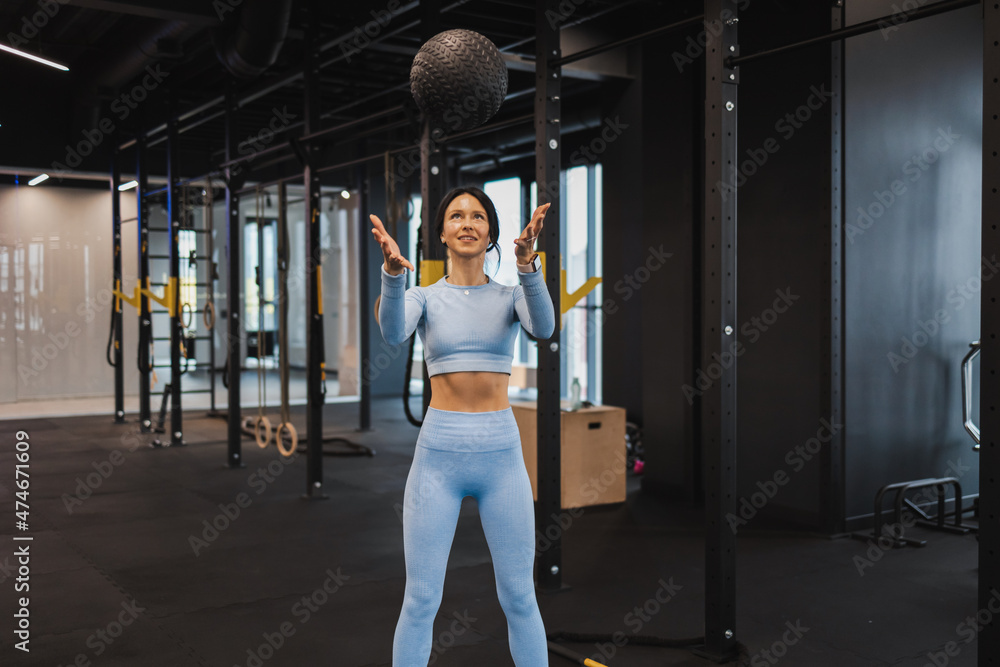 Fitness woman throwing up medical ball in the gym Stock Photo | Adobe Stock