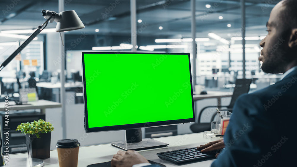Successful Black Businesswoman Sitting at Desk Working on Green Screen ...