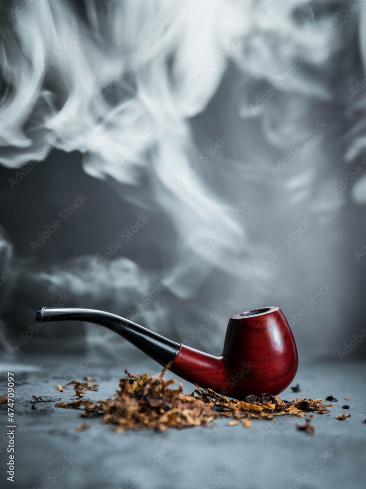 Smoking pipe, tobacco and smoke on a black background . Relax ...