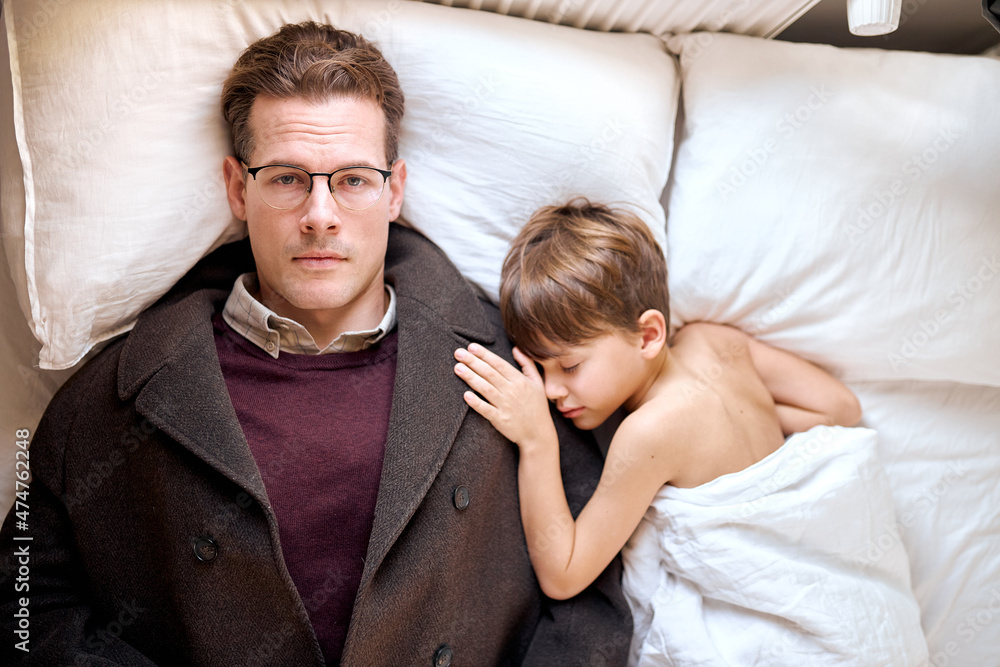 upset american father lying with little son before leaving for long ...