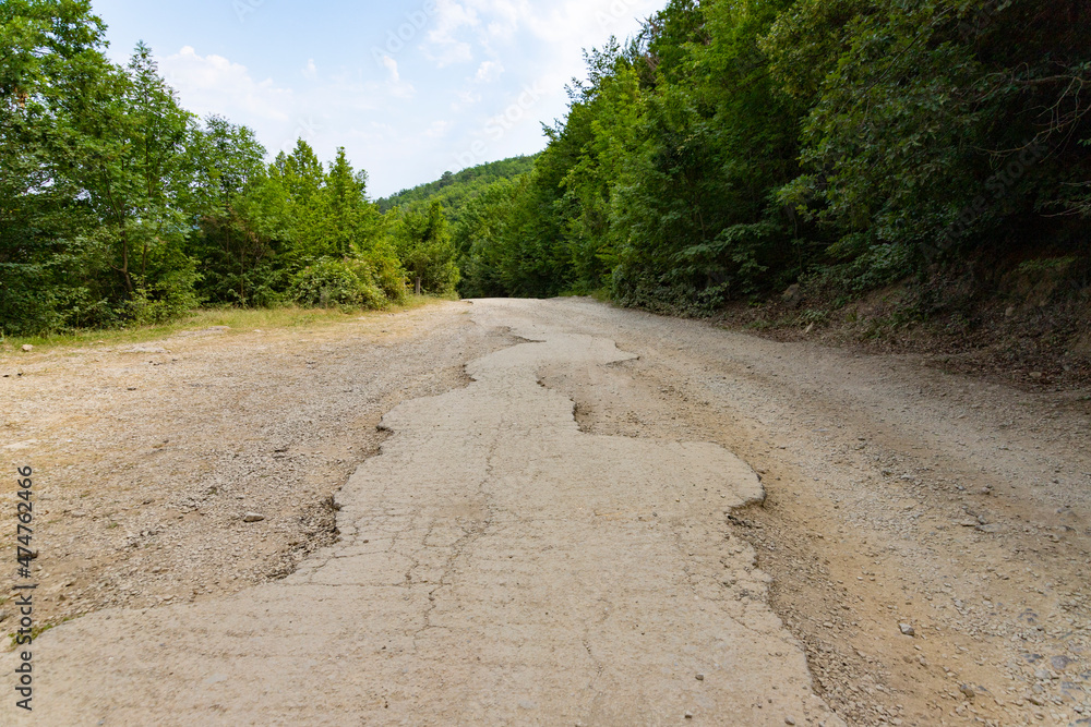 After an earthquake and a strong storm, the remains of an asphalt road ...