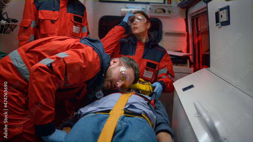 Paramedics resuscitating man in car. Medical staff saving life of patient Stock Photo | Adobe Stock