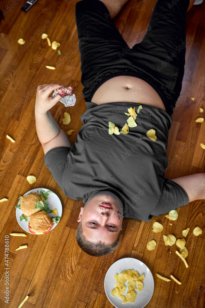 overeat fat boy eat junk food while lying on floor at home, with french ...