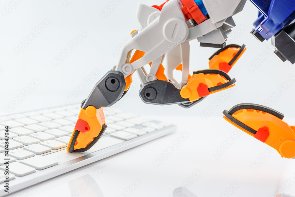 Robot index finger presses or touches a computer keyboard. Robot with ...
