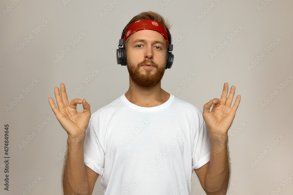 Attractive manful Caucasian guy with blond beard wearing wireless ...