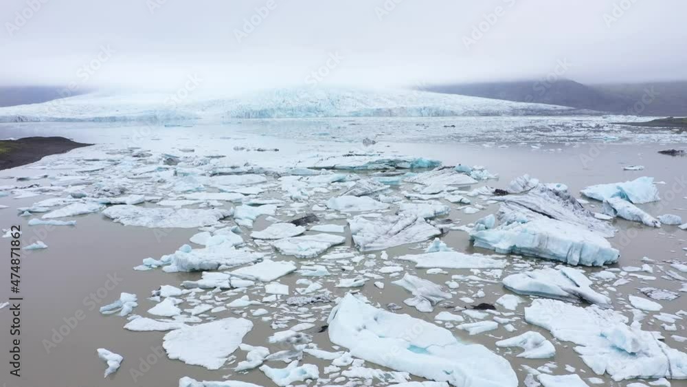 Flying over floating icebergs in Fjallsarlon glacial lagoon, Iceland ...