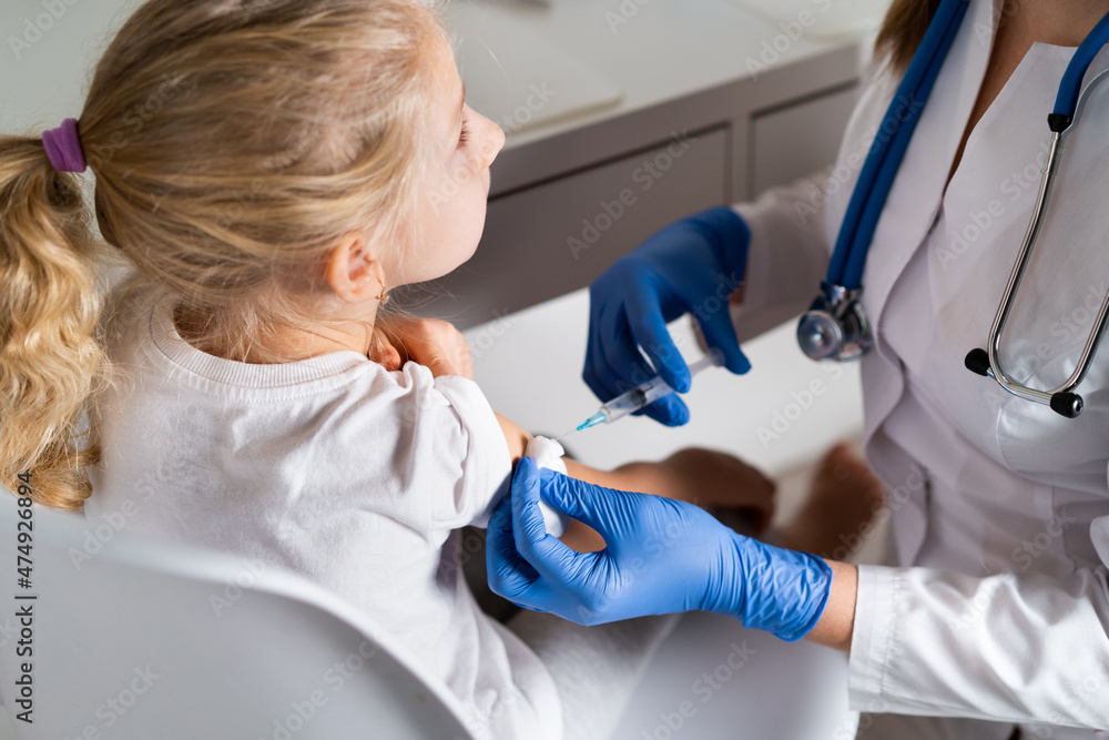 vaccination of children, a little girl at a doctor's appointment, an ...