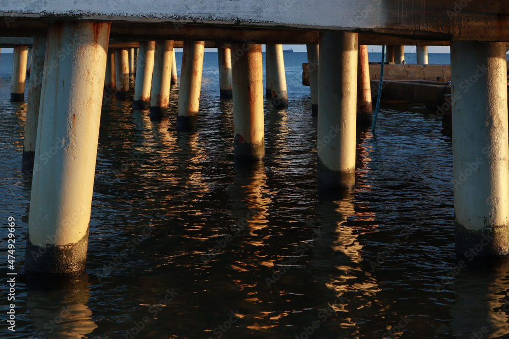 View of the sea water under the pier. Columns of the pier. Pier on the ...