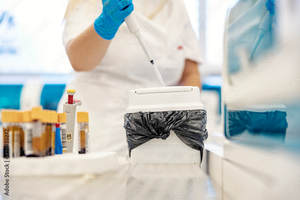 Medical waste in lab. A nurse taking care of medical waste after blood ...