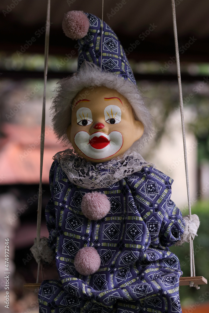 Halloween Party scary clown. Hanging toys. Clown sitting on a swing and ...