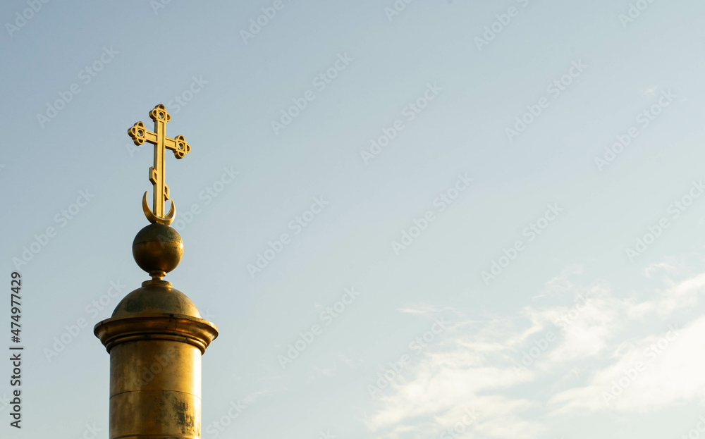 Golden Orthodox cross on a blue sky background. The cross on the dome ...