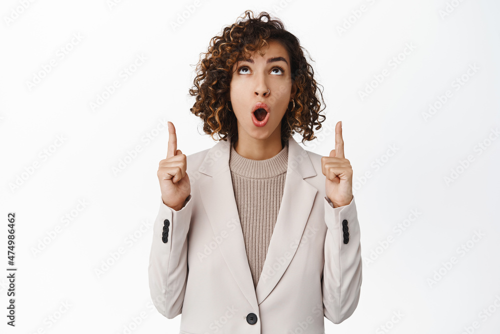 Shocked businesswoman drop jaw, pointing and looking up with impressed ...