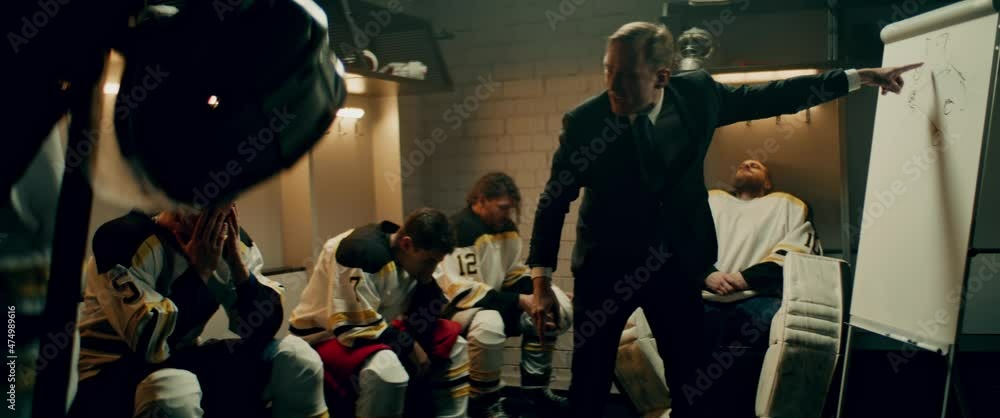 Angry disappointed coach yelling on players of ice hockey team in the ...
