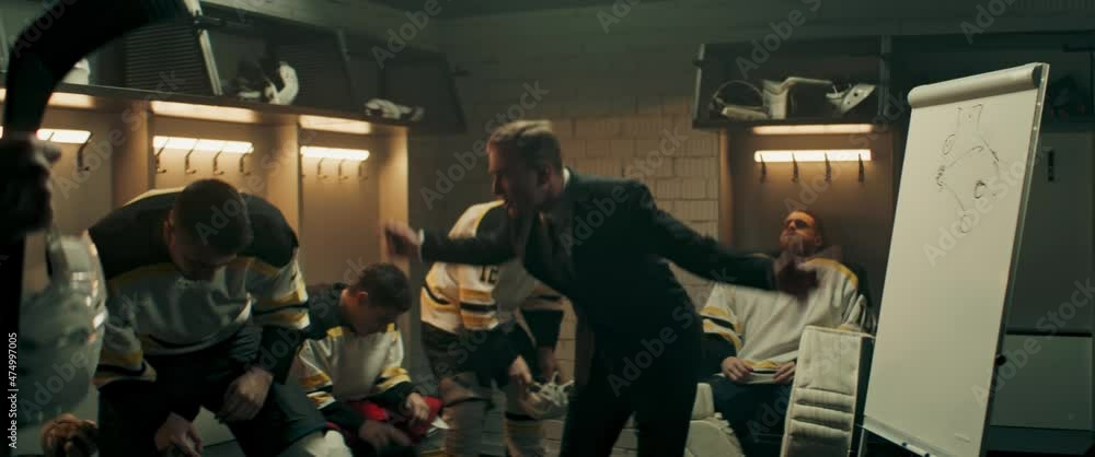 Angry disappointed coach yelling on players of ice hockey team in the ...