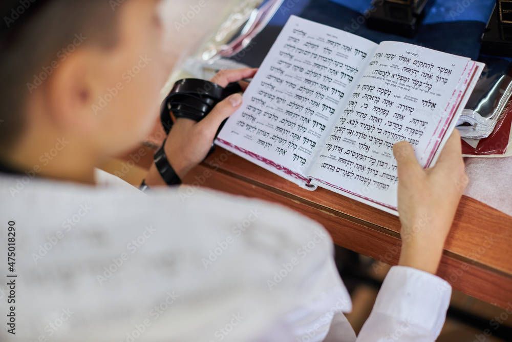 A young man finger pointing at a phrase in a bible book, while reading ...