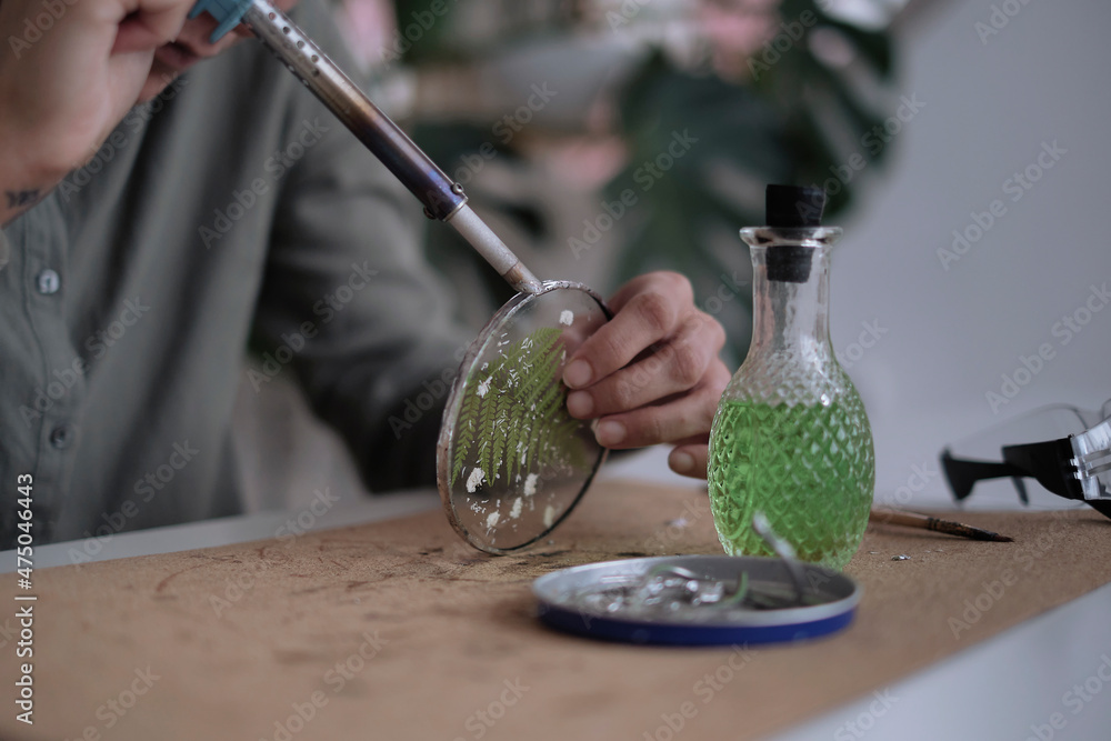 Stained glass maker works with colorful souvenirs. Female hands ...