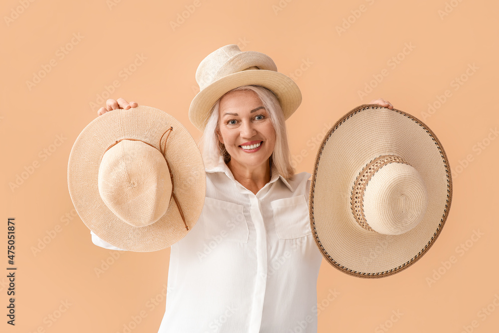 Beautiful mature woman with different straw hats on color background ...