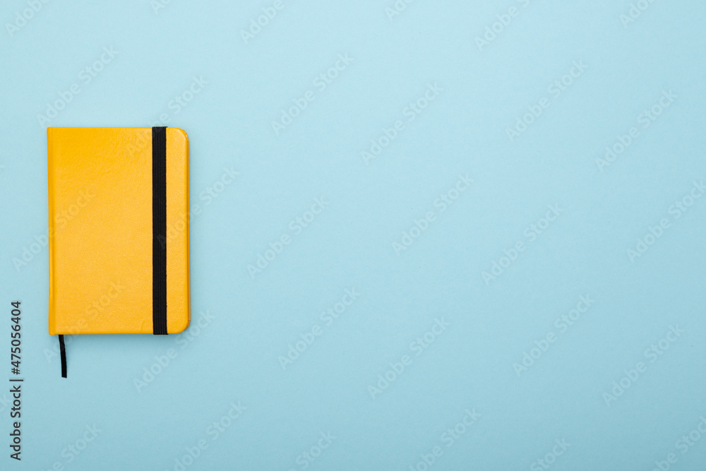 yellow notepad with a black bookmark lies on a blue background. Tool ...