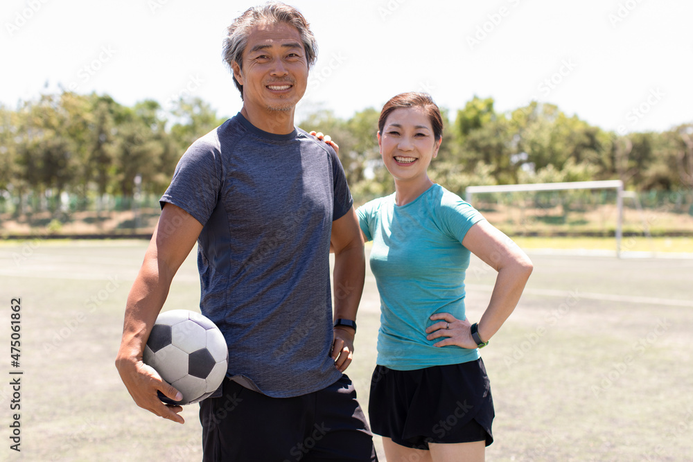 Happy mature couple playing football outdoors Stock Photo | Adobe Stock