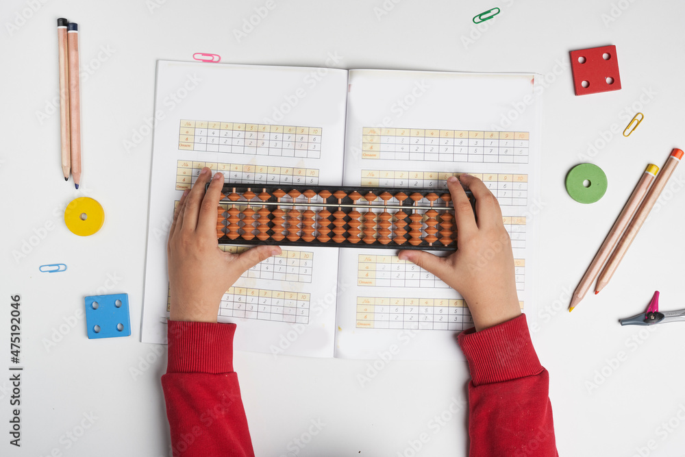 Doing mental math or mental arithmetic. Hand of little boy using abacus ...