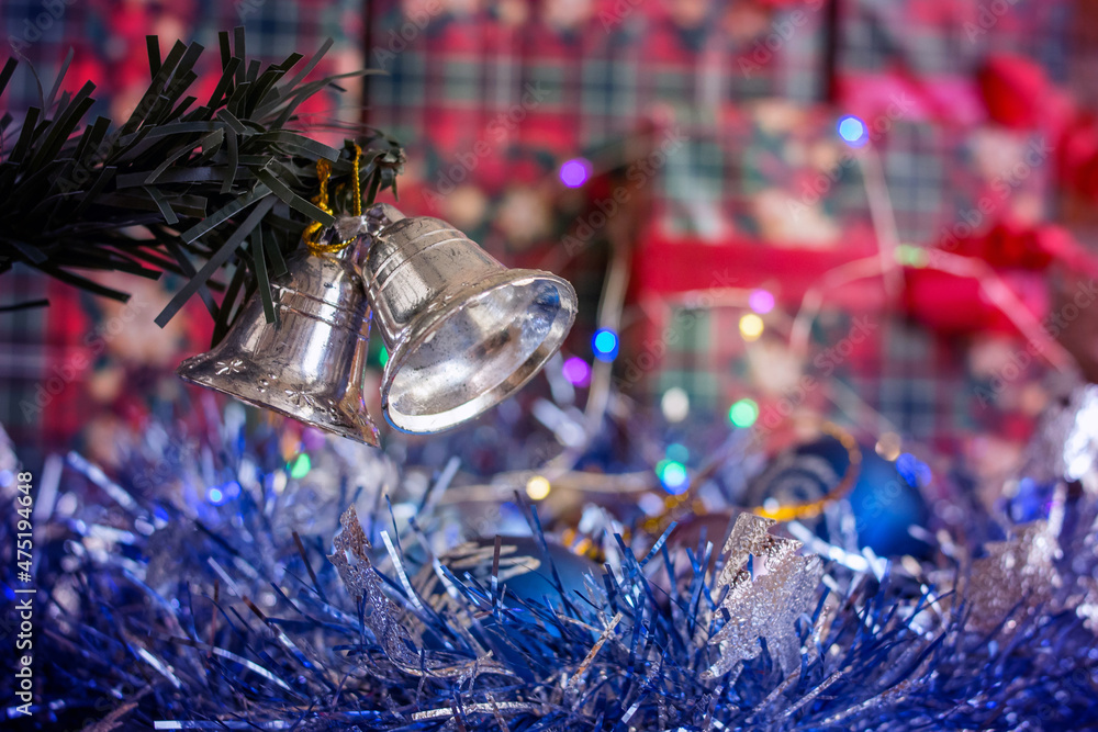 little silver bells hanging from a branch of a Christmas tree - closeup ...
