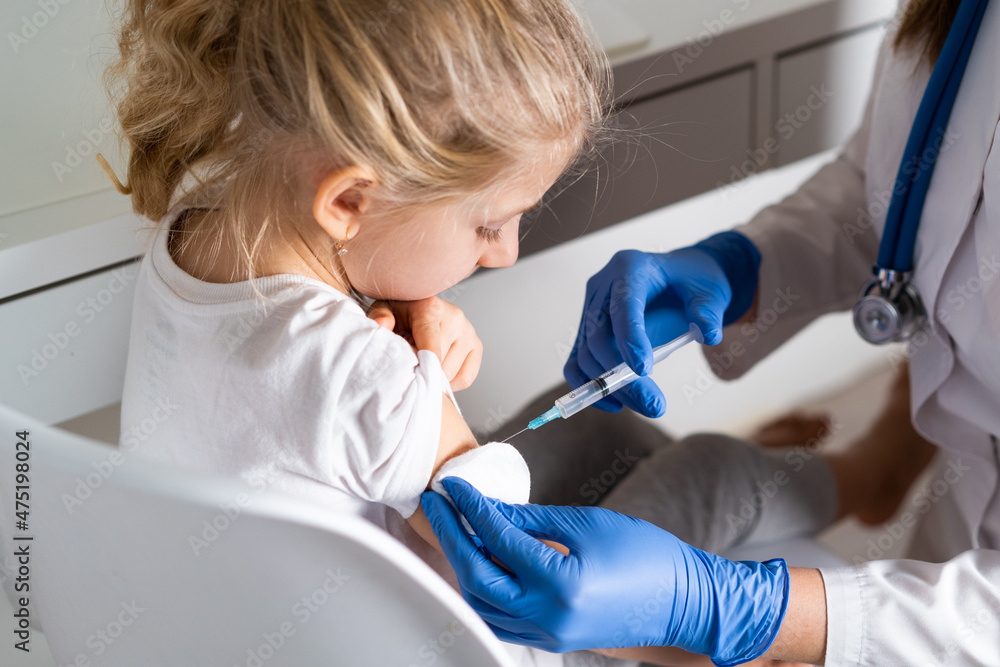 vaccination of children, a little girl at a doctor's appointment, an ...
