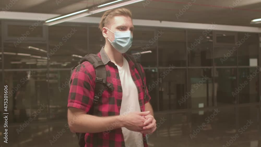 A young guy in a mask on his face gives a comment on the quarantine ...