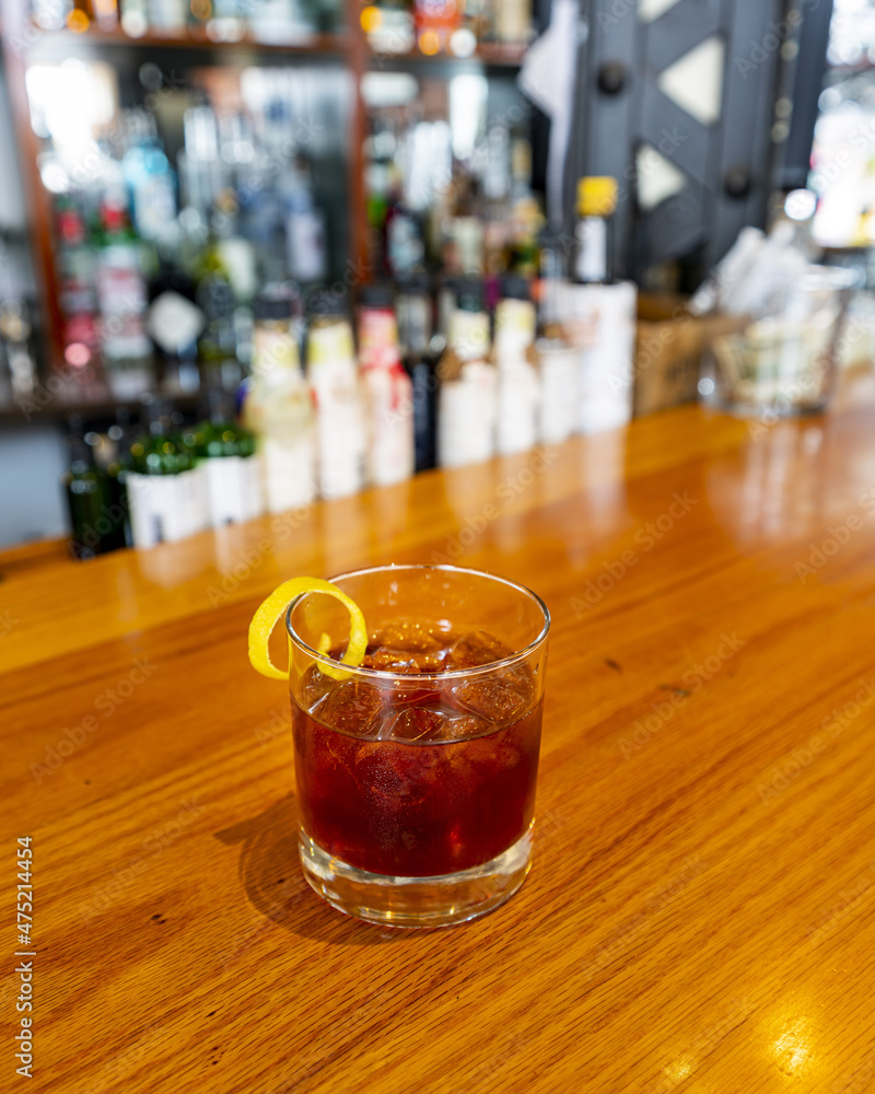 Stunning rum cocktail at a small speakeasy with a background of bitters ...